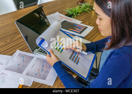 Female accountant analyzing financial data at laptops in bright home ...