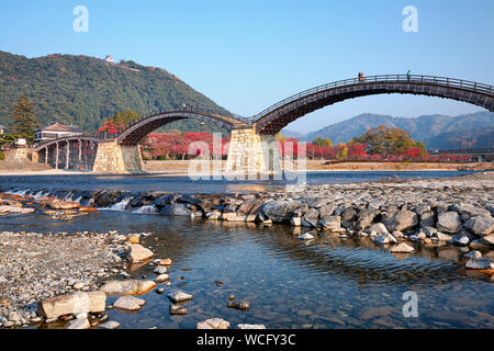 Red Japanese style bridge over stream in woodland in a large country ...