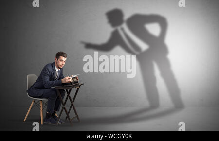 Little man working and a big shadow arguing with him Stock Photo - Alamy