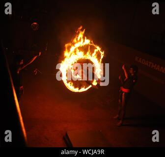A man is jumping through a ring of fire during the display of the Stock ...
