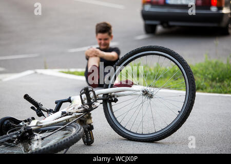 Teenage boy There is a knee injury, as the bike falls while riding. Kid ...