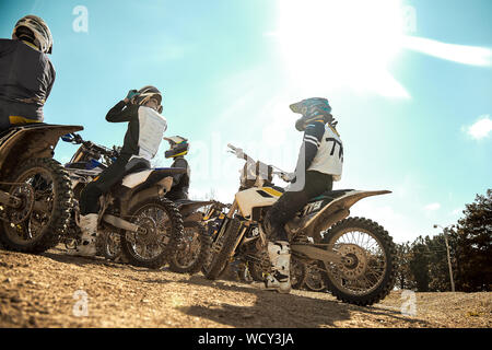 Rear view of several off-road vehicles parked on a dirt lot, including ...