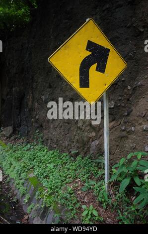 Closeup shot of a yellow turn sign on a road Stock Photo - Alamy