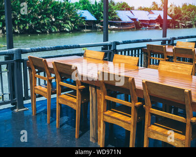 Empty wooden dining table set near the green garden Stock Photo - Alamy