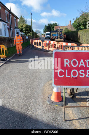A road closed sign on a suburban British street. Yellow barriers ...