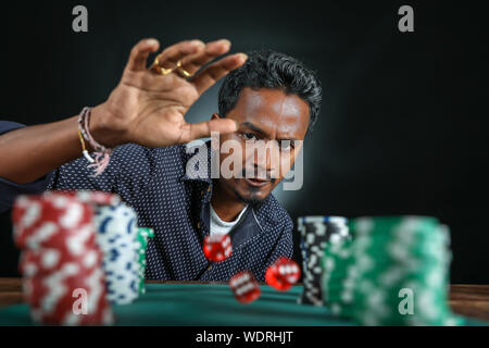 Man rolling dice Stock Photo - Alamy