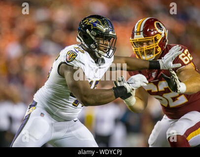 Baltimore Ravens linebacker Jaylon Ferguson, right, warms up during NFL ...