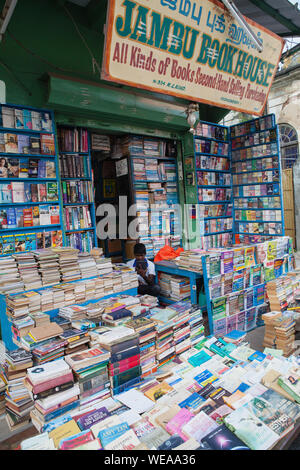 India, Pondicherry, Second-hand bookshop in market with seller using ...