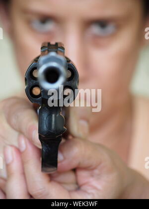 Woman handling, pointing and shooting a gun; a long barrel .38 special ...