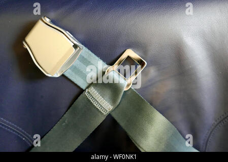 Close-up of a safety belt in the airplane. male hand tightens the ...