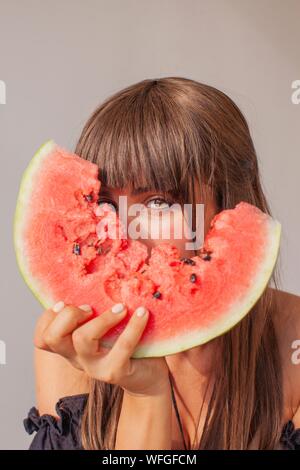 Young woman hiding behind her shoulder Stock Photo - Alamy