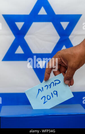 Israeli man putting a ballot in a ballot box on election day. Close up ...