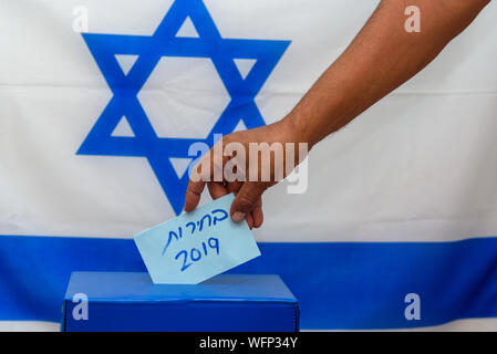 Israeli man putting a ballot in a ballot box on election day. Close up ...