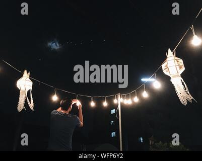 Hanging light bulbs with glowing one isolated on dark green background ...