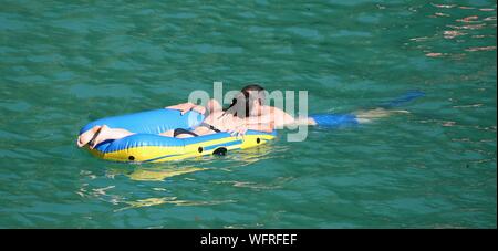 A woman relaxing on an inflatable raft in a swimming pool Stock Photo ...