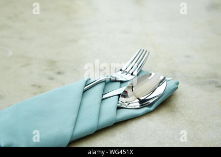 Table setting of Cutlery wrapped in cloth napkin on plate Stock Photo ...