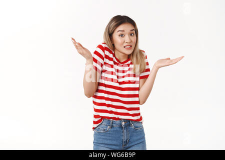 Oops sorry. Apologizing asian girl spread hands sideways, shrugging ...