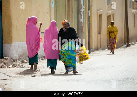 Harari women walking in the street wearing colourful clothing. Harar ...