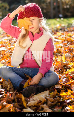 Autumnal portrait of a girl among leaves Stock Photo - Alamy