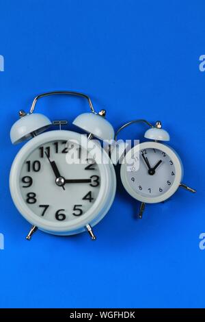 Clock marking winter time change in autumn blue background Stock Photo ...