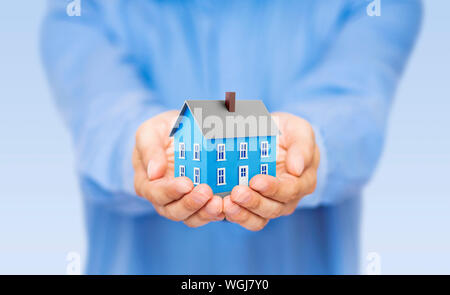 Small blue toy house in hands Stock Photo - Alamy