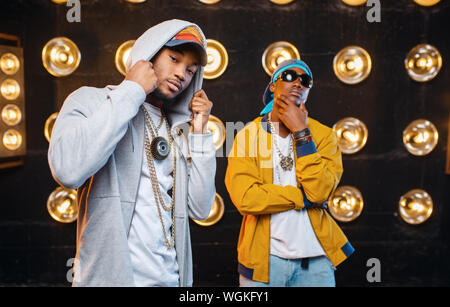 Two black rappers in caps, artists on stage with spotlights on ...