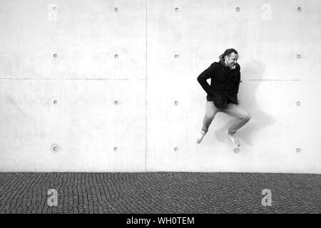 Young man jumping over the wall. Parkour in the urban space. Sport in ...