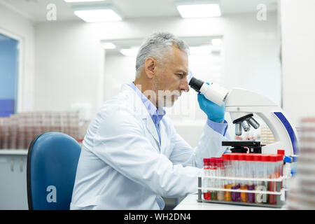 Bearded scientist man in lab coat gesturing with hands against a white ...