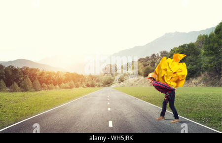 Builder man carrying paper ball on his back Stock Photo - Alamy