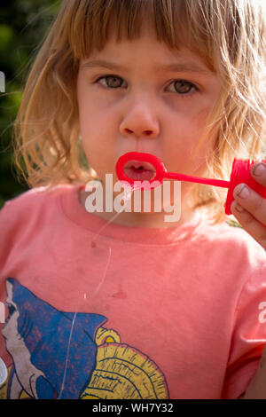 Child blowing bubbles outside in the summer Stock Photo - Alamy