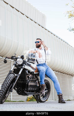 Portrait of man leaning on motorcycle Stock Photo - Alamy