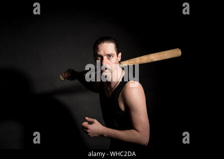 Angry looking man with bat Stock Photo - Alamy