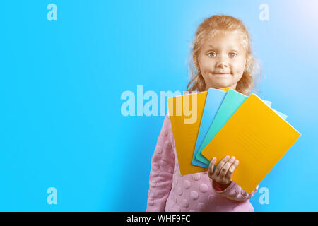 A cute cheerful girl with dimples on her cheeks and curly hair smiles ...