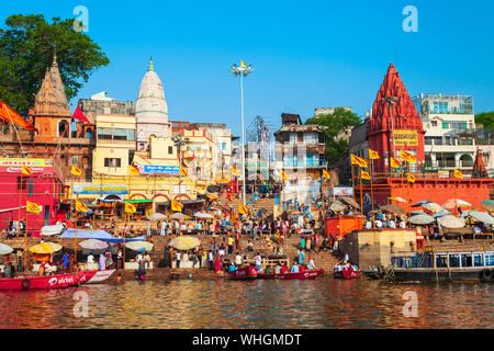 VARANASI, INDIA - APRIL 12, 2012: Colorful boats and Ganges river bank ...