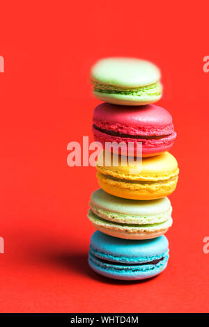 Tasty french macarons on a red background. Place for text. Flat lay ...