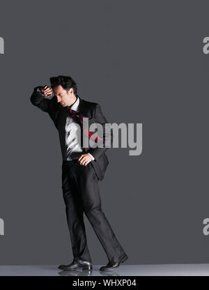 Young Businessman shielding face with arm from wind, side view Stock ...