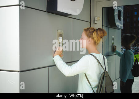 Woman using intercom Stock Photo - Alamy