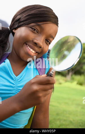 Children using a magnifying glass to examine an area of grass Stock ...