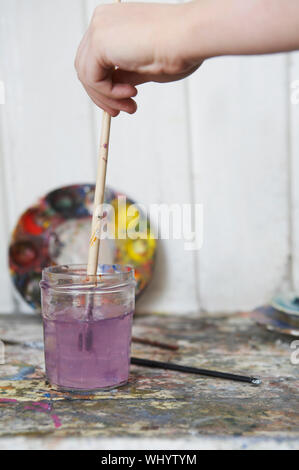 Watercolor painting. Woman artist is cleaning paintbrush in water and ...
