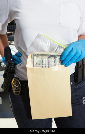 Police Officer Putting Money in Evidence Envelope Stock Photo - Alamy