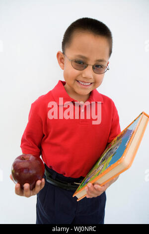 Adorable hispanic boy student holding test tube at laboratory classroom ...