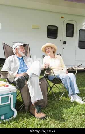 Senior couple sitting in RV holding coffee cups and smiling Stock Photo ...