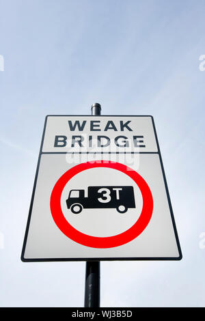 Isolated weak bridge sign with weight and width restrictions. Stormy ...