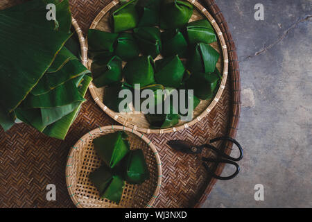 Cakes wrapped in banana leaves on a white background Stock Photo - Alamy