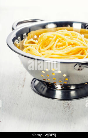 spaghetti in colander over white Stock Photo - Alamy