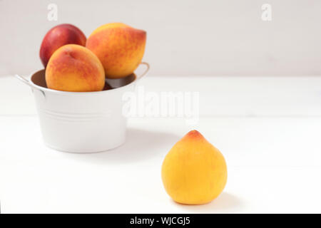 Yellow italian fresh peach percoche on the white wooden background with ...