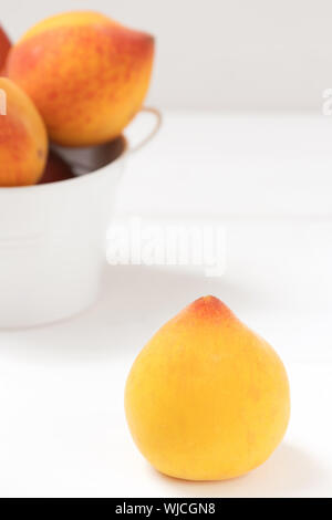 Yellow italian fresh peach percoche on the white wooden background with ...