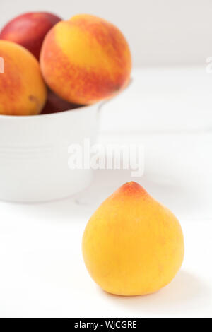 Yellow italian fresh peach percoche in a white bucket on the white ...