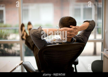 Man relaxes and puts his feet up on a garden table Stock Photo - Alamy