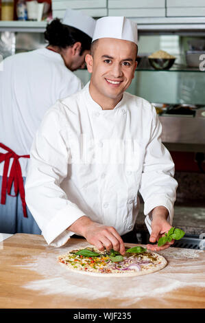 Male chefs preparing food behind counter at illuminated restaurant ...